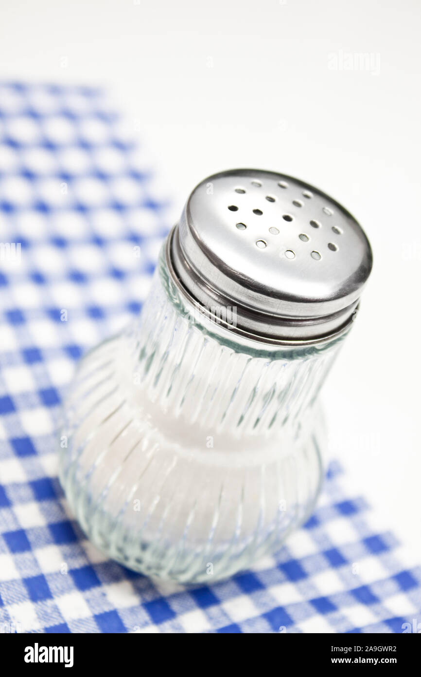 Salt and salt shaker on checked background Stock Photo - Alamy