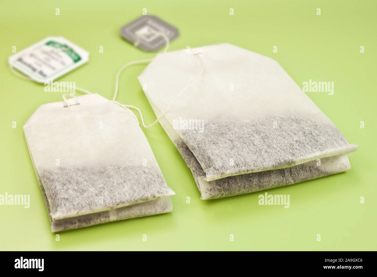 Two tea bags and green background Stock Photo - Alamy
