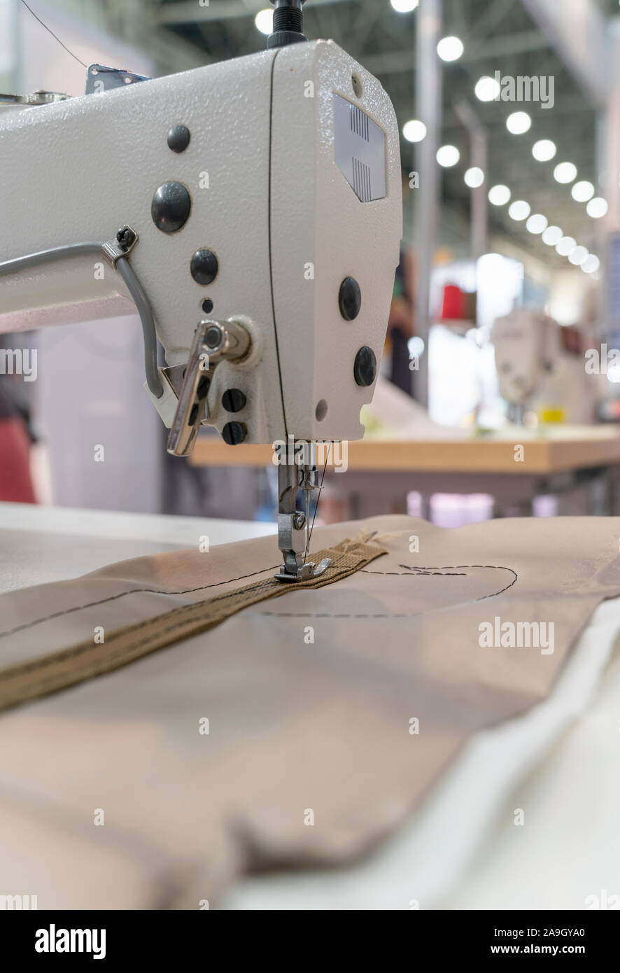 Clothes fabrication on a modern sewing machine. Vertical image Stock ...