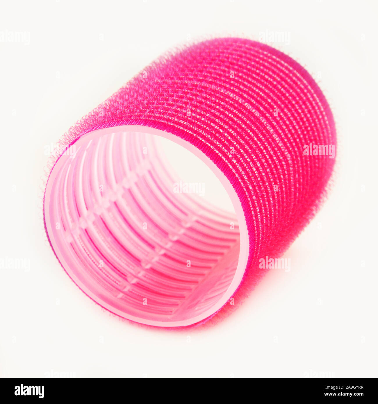 Hair styling pink curler on white background Stock Photo - Alamy