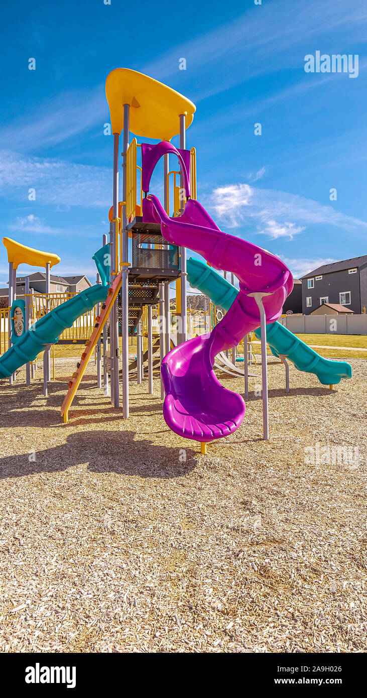 Vertical frame Brightly colored purple and blue slides during day Stock ...