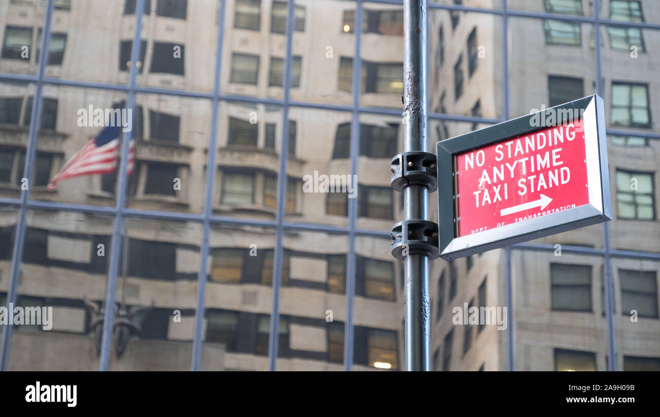 Taxi stand sign in New York City in front of reflection of skyscrapers ...