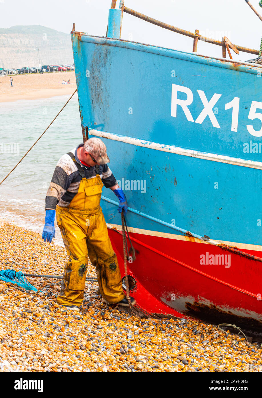 Fisherman beaching his fishing boat Stock Photo - Alamy