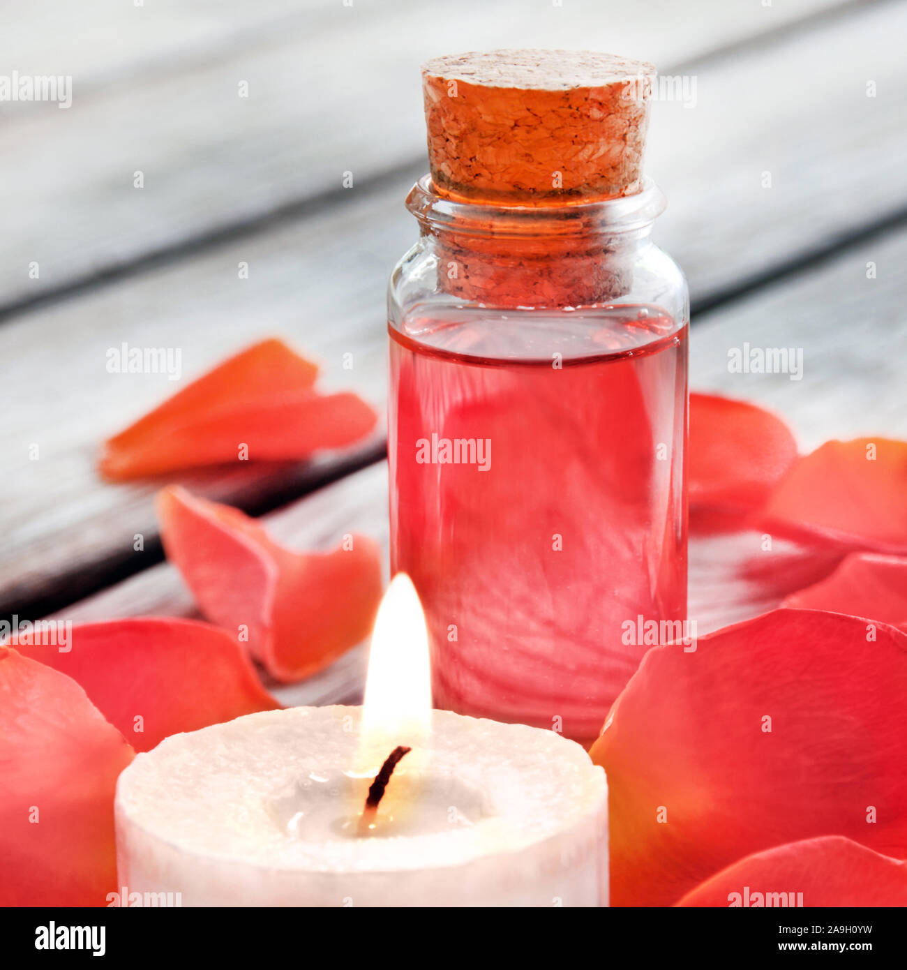 Wellness rose oil and candle Stock Photo - Alamy