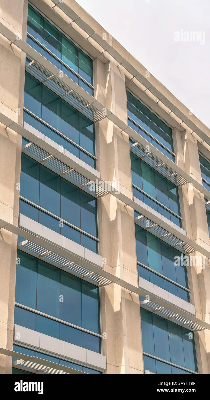 Vertical frame Modern building facade close up with glass windows and ...