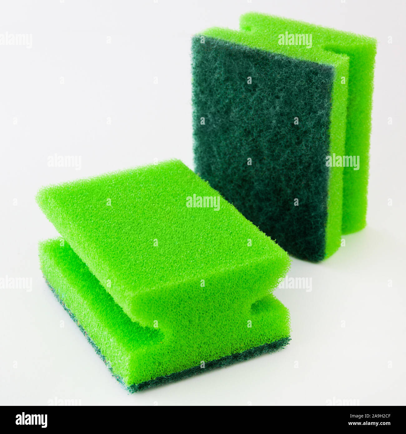 Cleaning products green sponges and white background Stock Photo - Alamy