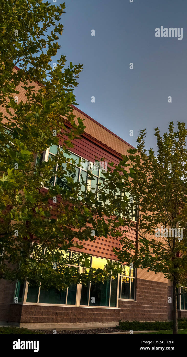Vertical Suburban townhouse facade with trees near sunset Stock Photo ...