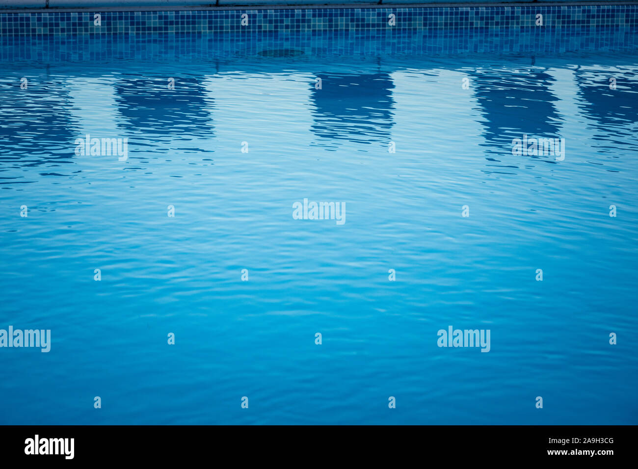Abstract reflections of loungers in a blue swimming pool Stock Photo ...