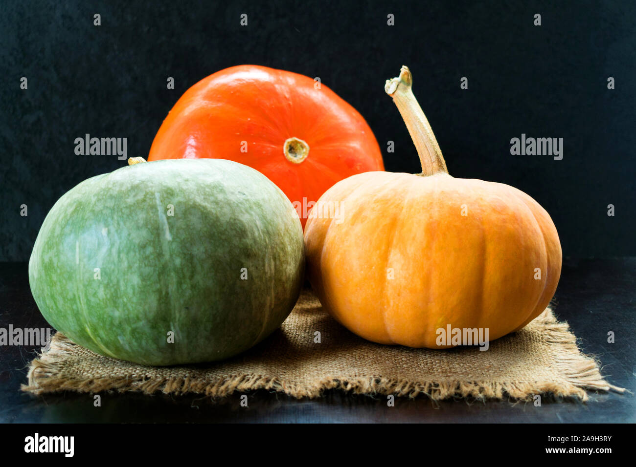 Three pumpkins of different colors on a black background Stock Photo ...