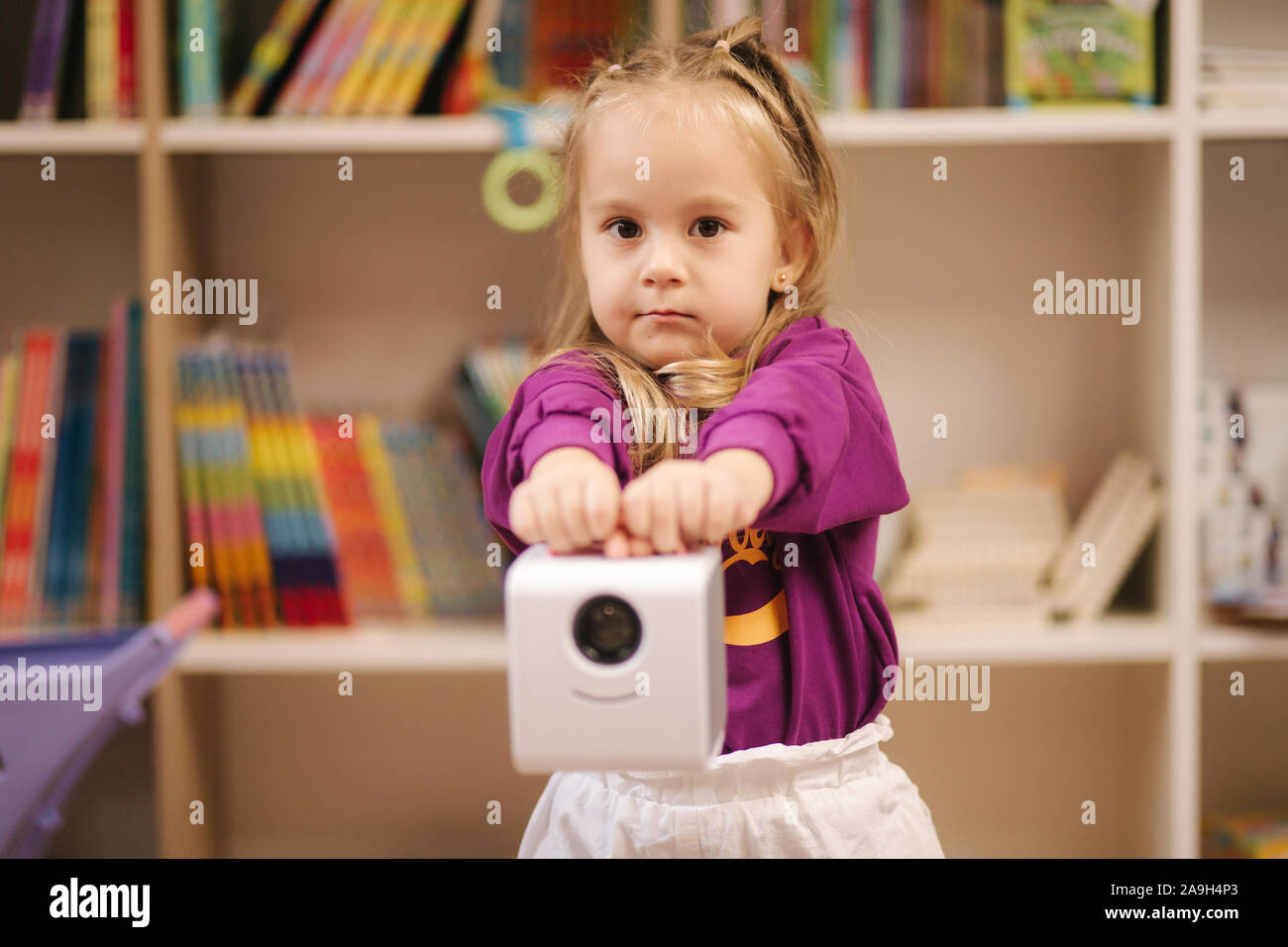 Adorable little girl shopping for toys. Cute female in toy store. Happy ...
