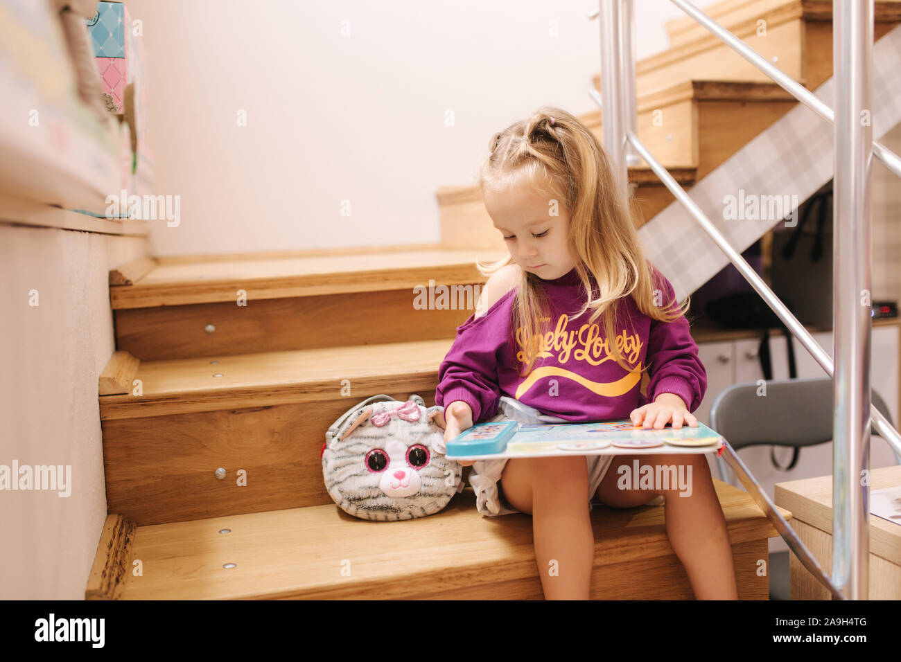 Beautiful little girl read interactive book in toy store Stock Photo ...