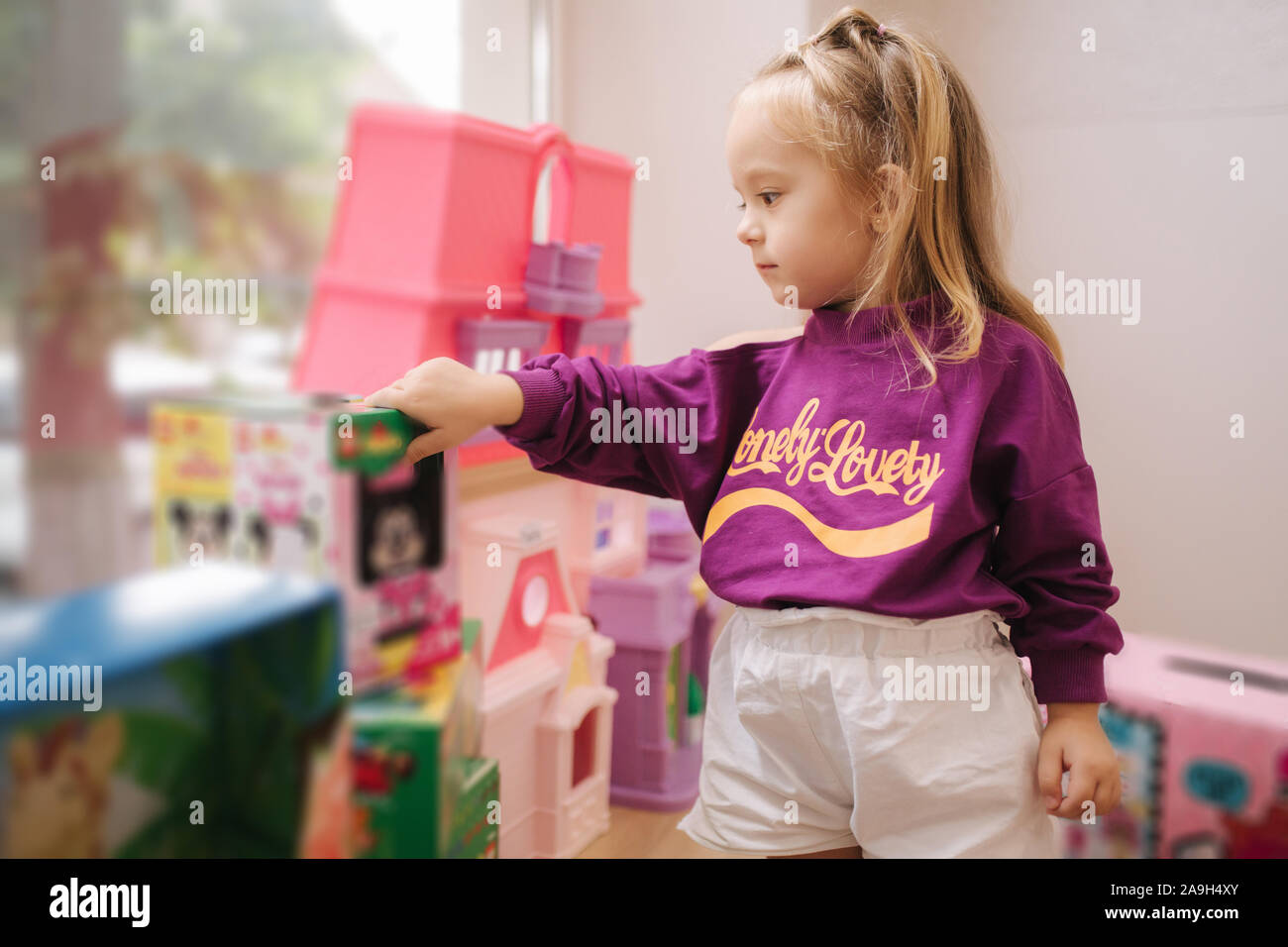 Happy little girl walkning in toy store. Cute girl choose toy. Adorable ...