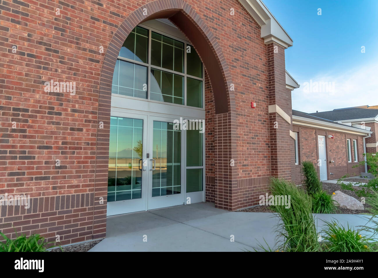 Arched entrance of a church with white framed double glass door and ...