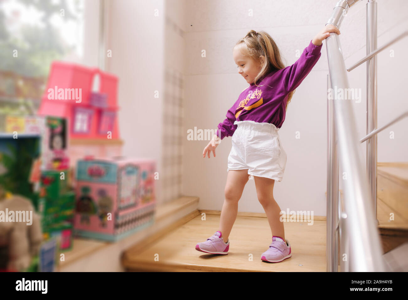 Happy little girl walkning in toy store. Cute girl choose toy. Adorable ...