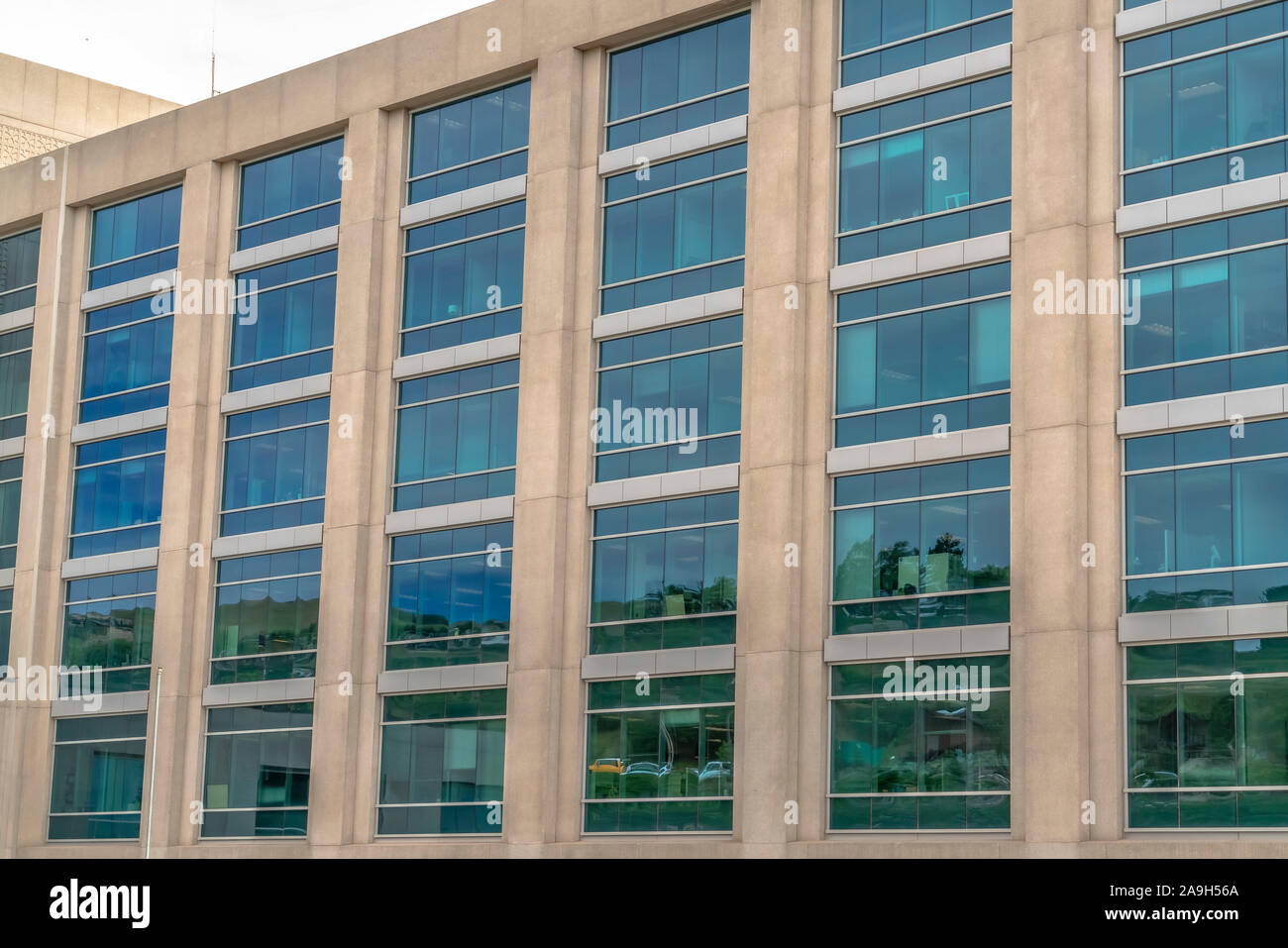 Modern office building exterior with concrete wall and large glass ...