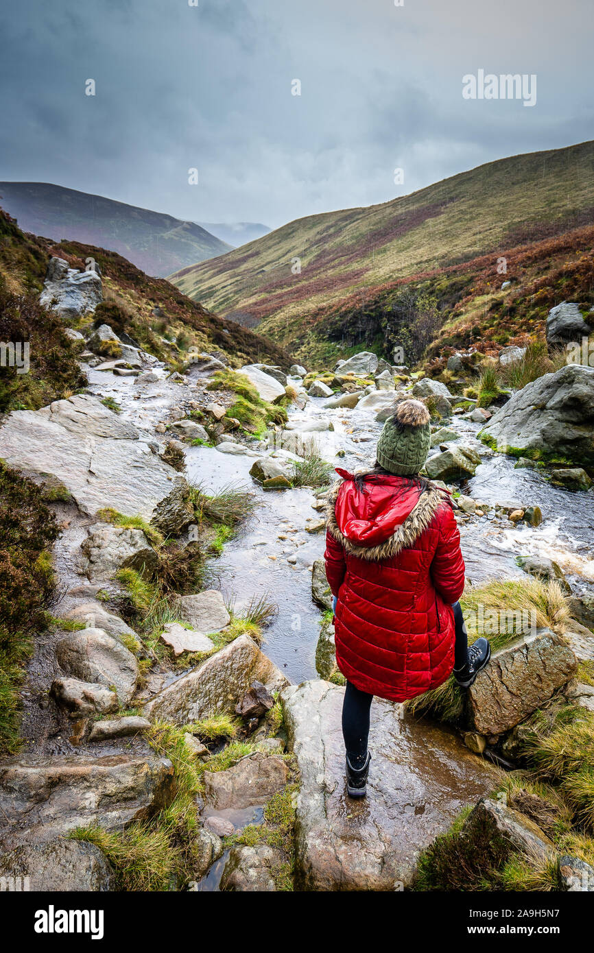 A women wearing a warm read coat hiking, mountain climbing at Kinder ...