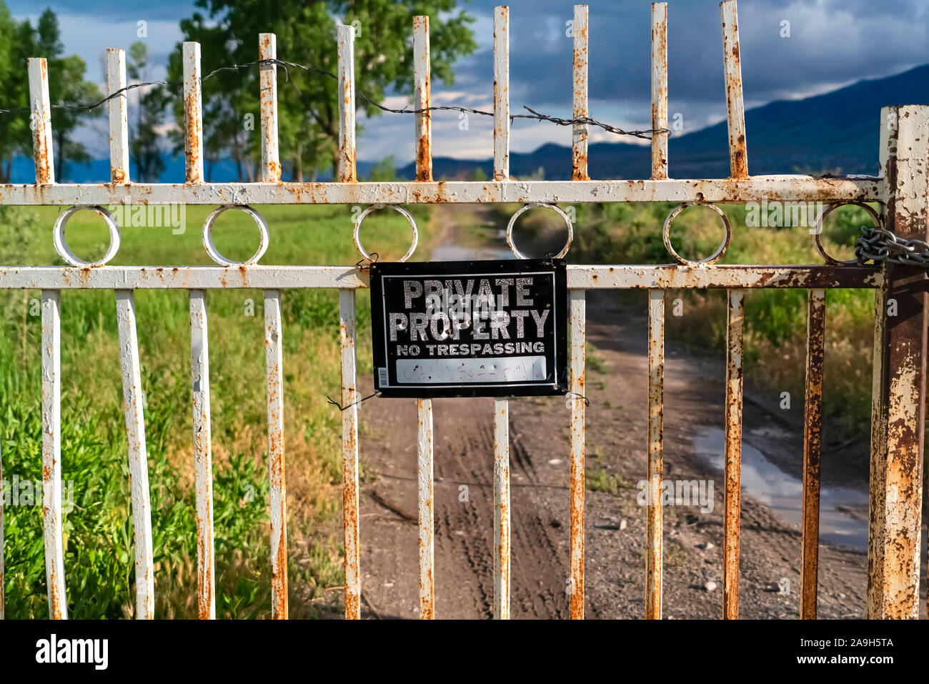 Close up of a locked gate at a private property with view of lake and ...