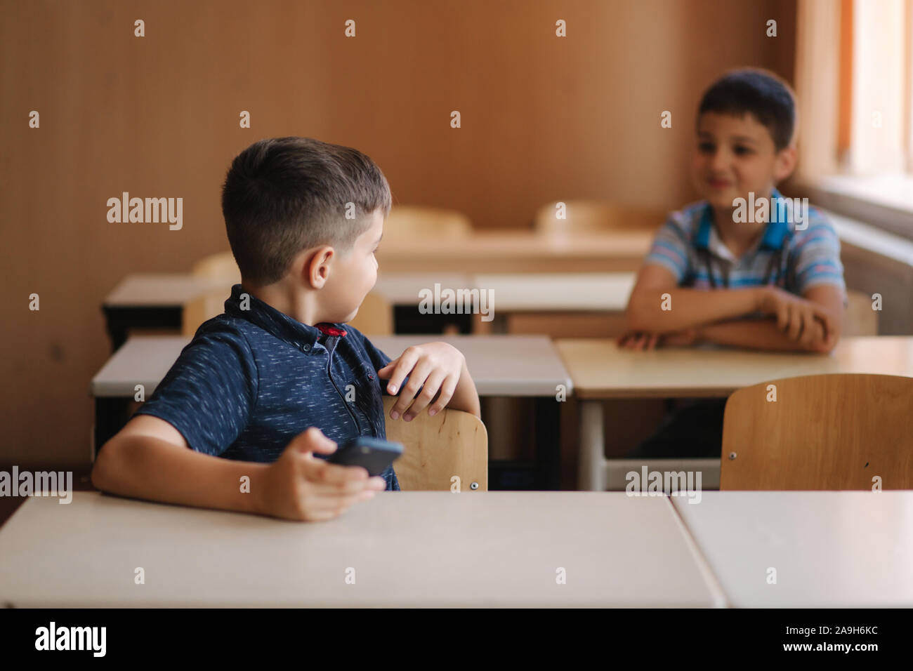 Cute little boy use phone during lesson. Two schollboy in class Stock ...
