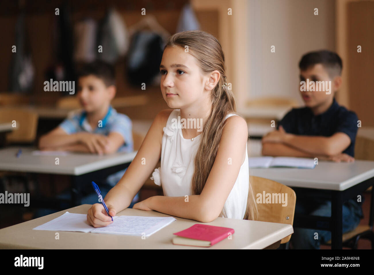 Boy and girl sitting at desk and writing a text Stock Photo - Alamy