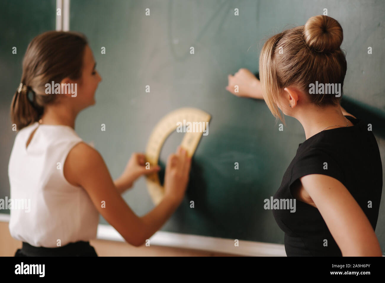 Teacher help girl by the blackboard. Young female teacher study Stock ...