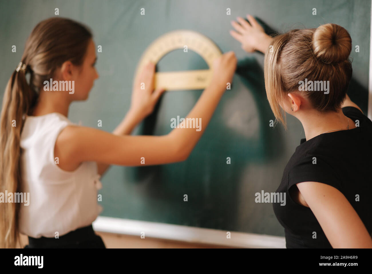Teacher help girl by the blackboard. Young female teacher study Stock ...