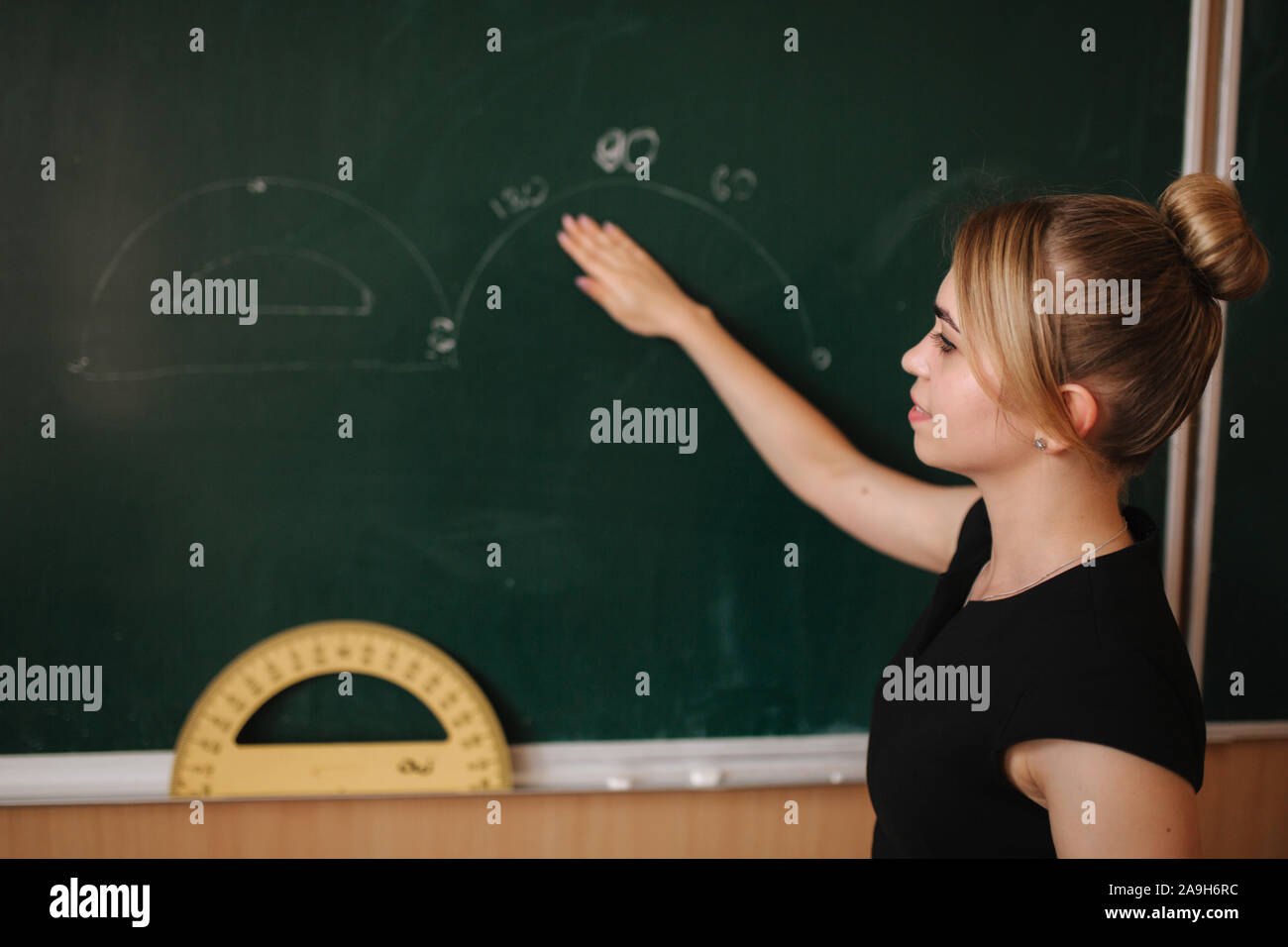 Teacher help girl by the blackboard. Young female teacher study Stock ...
