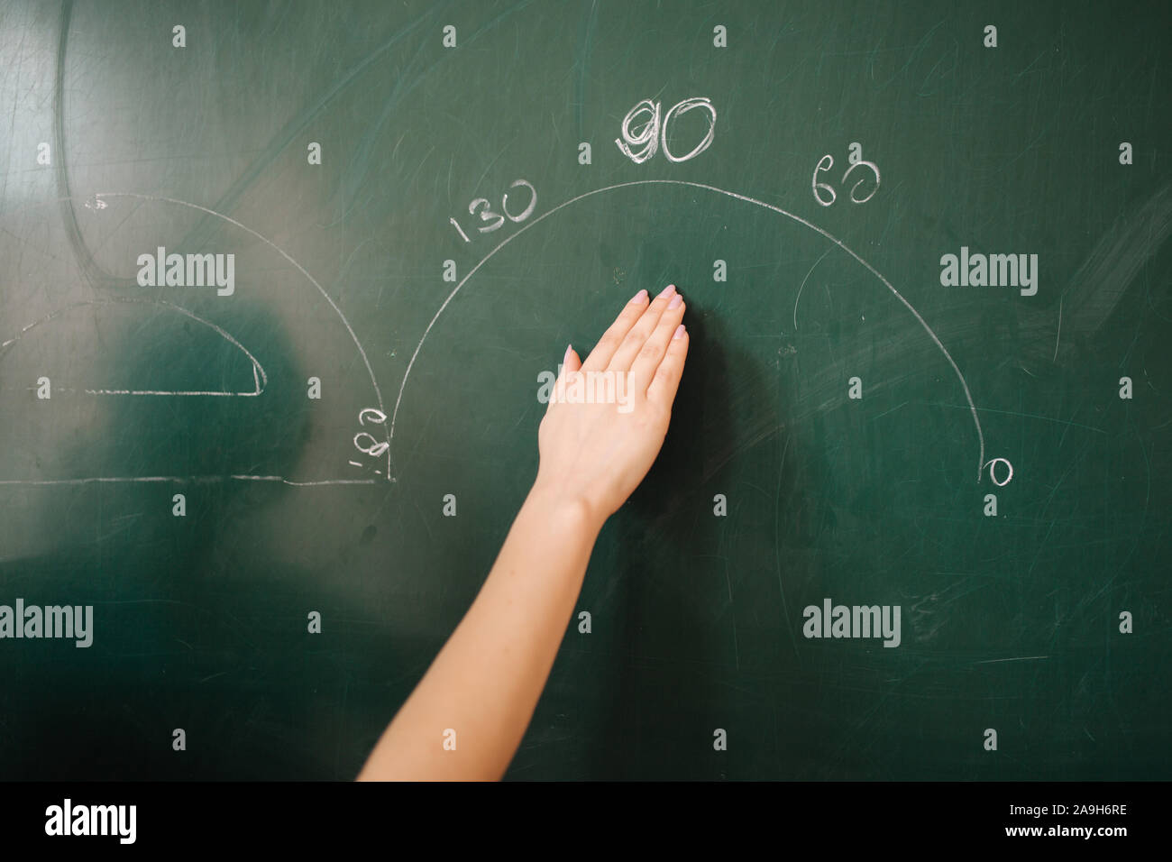 Hand of female teacher shows something on blackboard Stock Photo - Alamy