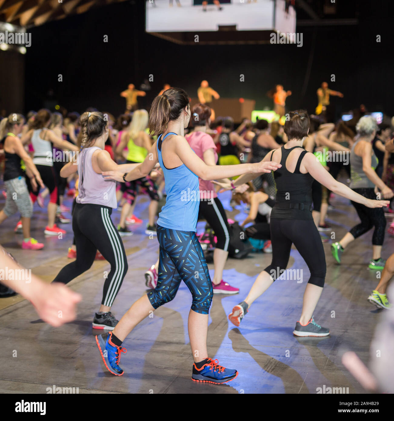 Fitness Workout in Gym: People doing Exercises in Class with Music and ...