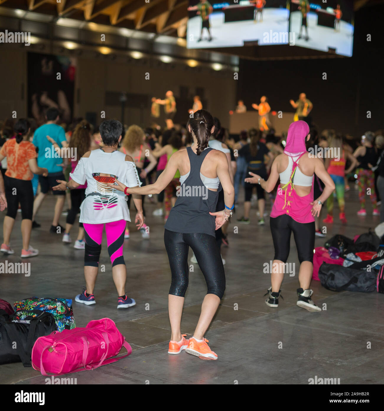 Fitness Workout in Gym: People doing Exercises in Class with Music and ...