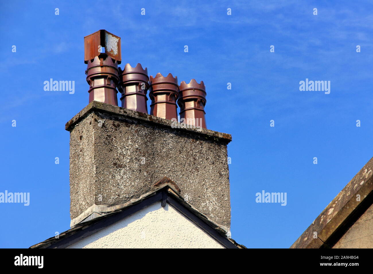Row of four old ornate ceramic chimney pots on a rooftop chimney stack ...