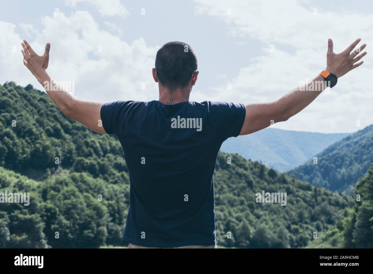Happy man looking on mountain valley standing back to camera Stock ...