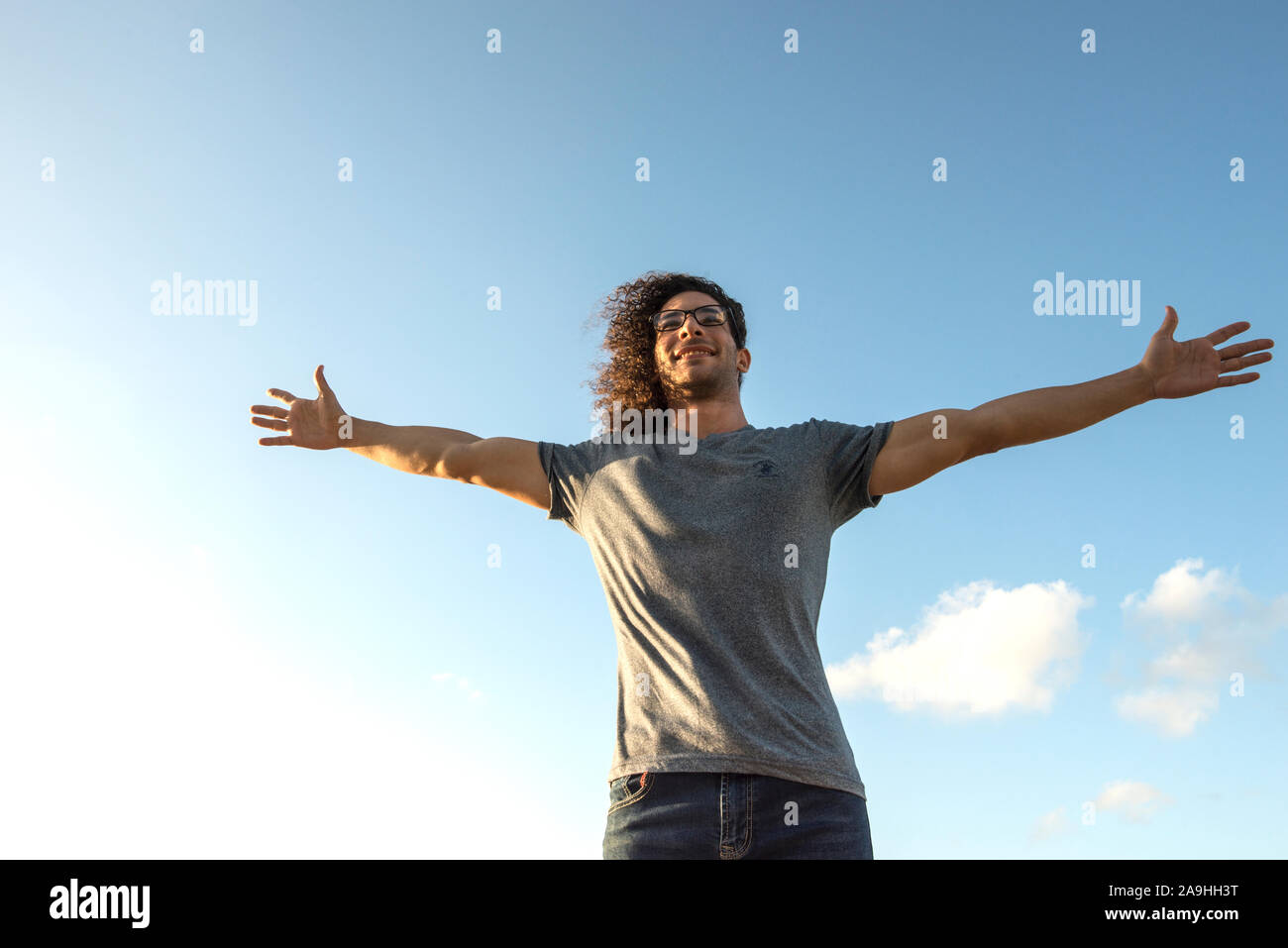 Young Latin man with arms outstretched Stock Photo - Alamy