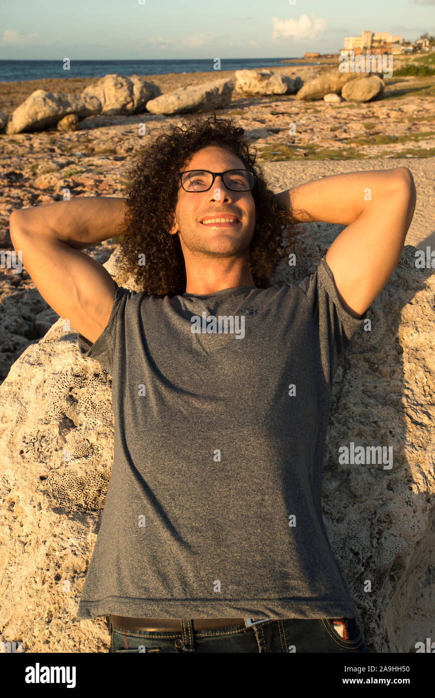 Young Latin man relaxed on the beach Stock Photo - Alamy