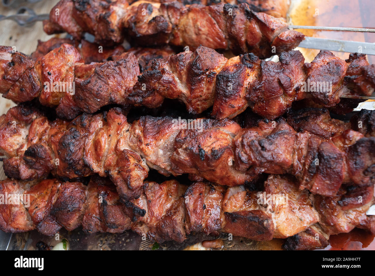 Grilled kebab cooking on metal skewer. Roasted meat cooked at barbecue ...