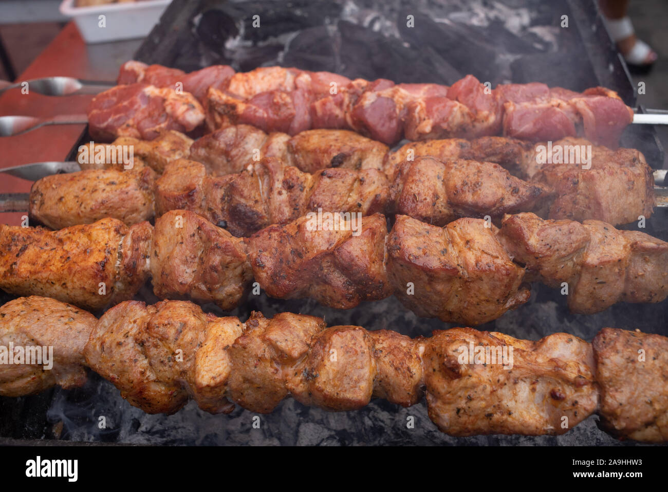Grilled kebab cooking on metal skewer. Roasted meat cooked at barbecue ...