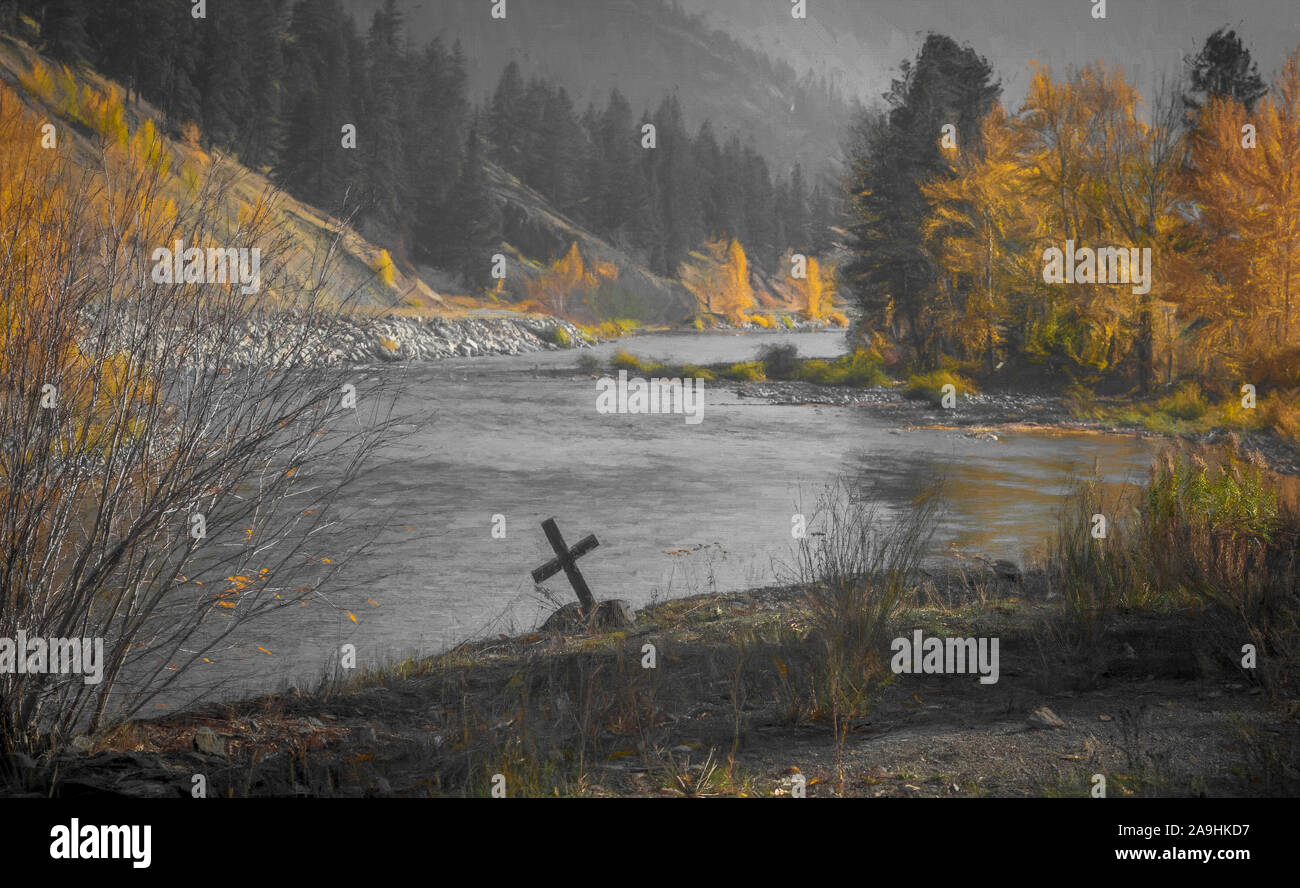 A memorial cross on the side of a river - textured and de-saturated ...