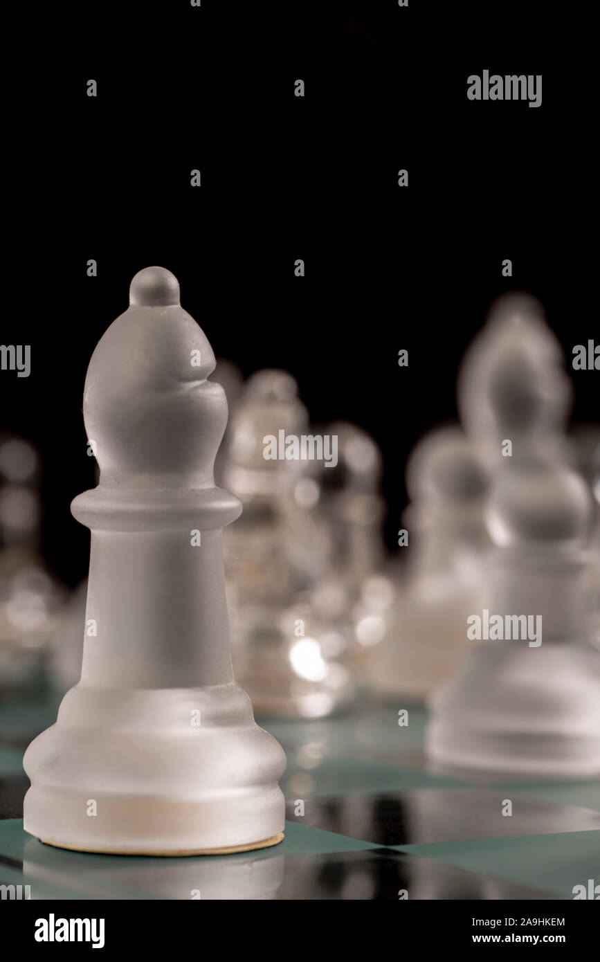 Pieces on a glass chess board - Bishop, pawn Stock Photo - Alamy