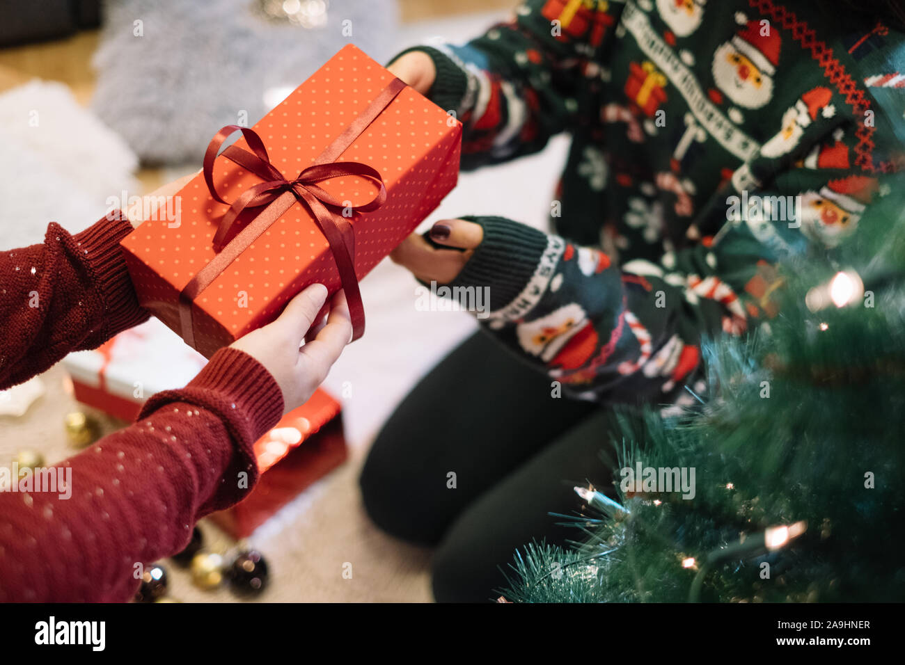 Childs hands giving red present to womans hands Stock Photo - Alamy