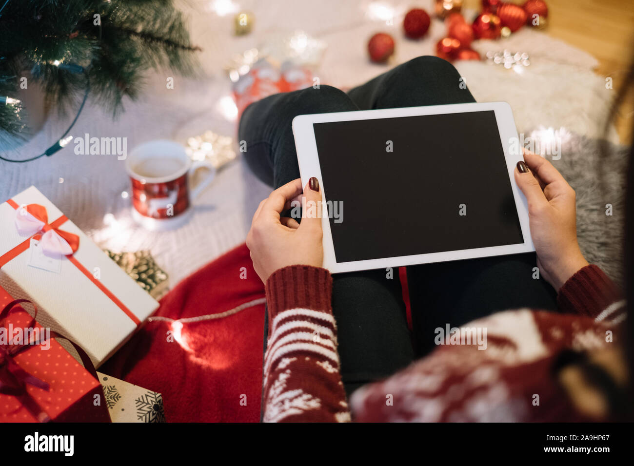 Girl holding tablet while sitting on floor Stock Photo - Alamy