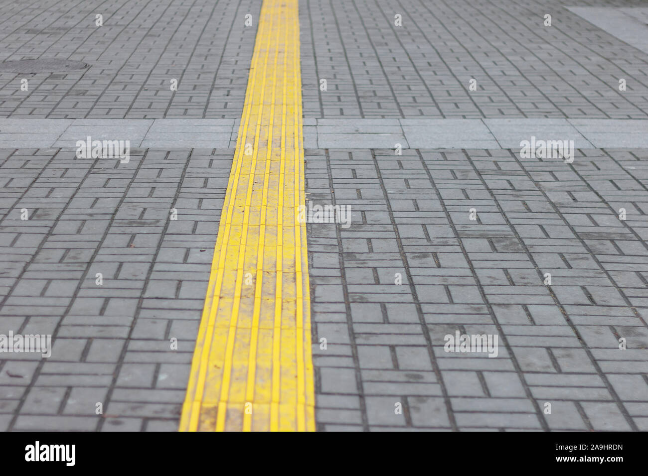 yellow line for blind people on gray pavers. perspective.copy space ...
