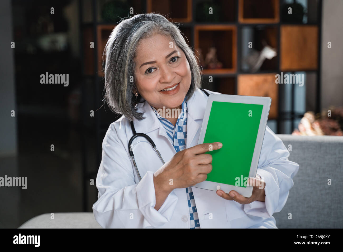 senior doctor pointing screen of tab Stock Photo - Alamy