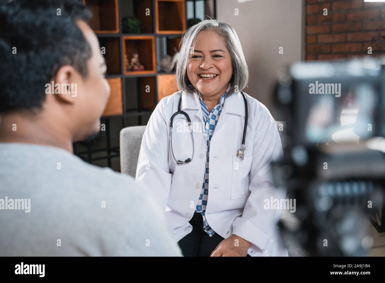 smiling doctor speaking to the patient and recording with camera Stock ...