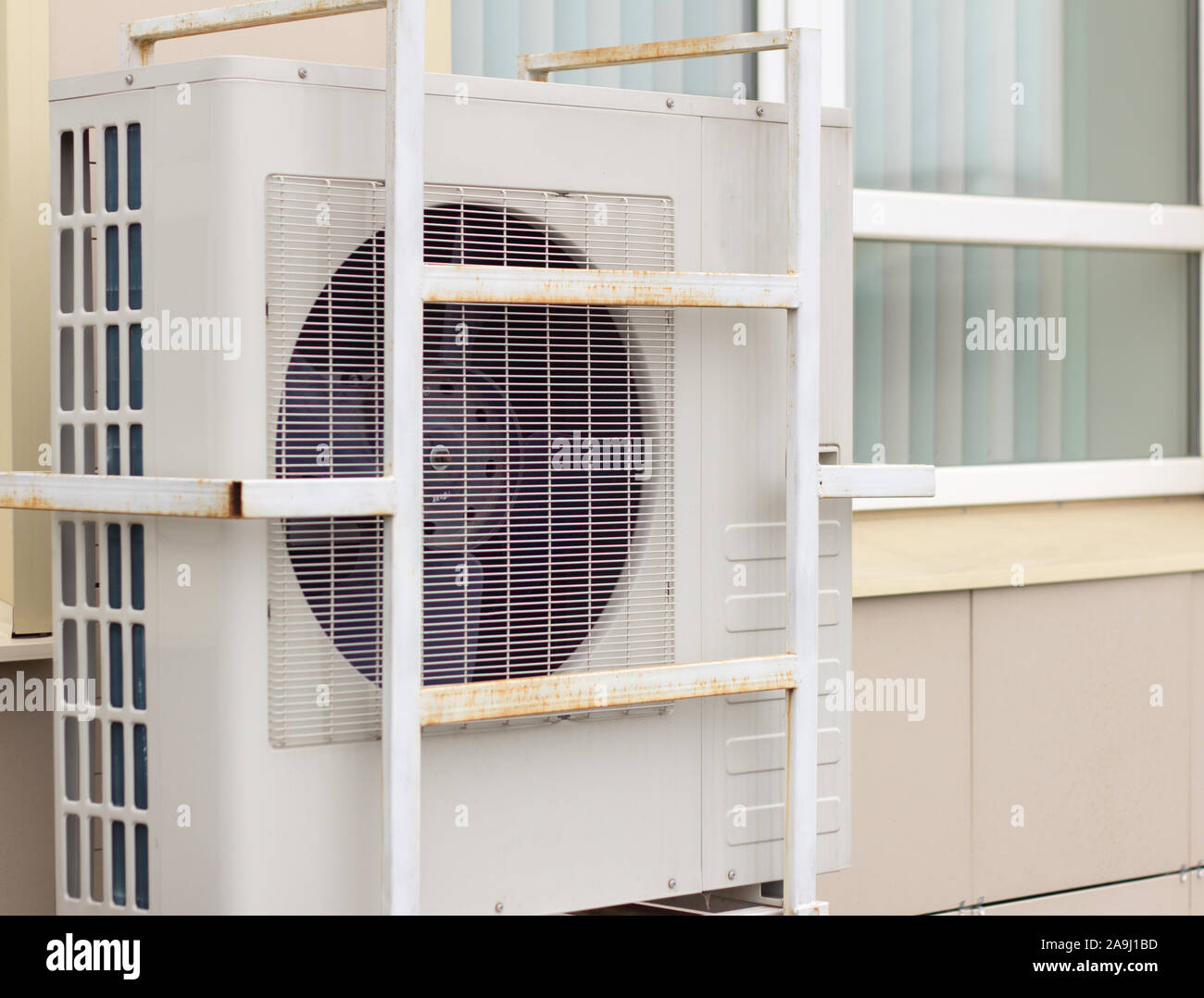 Air conditioning compressor on the outside wall of the house next to ...