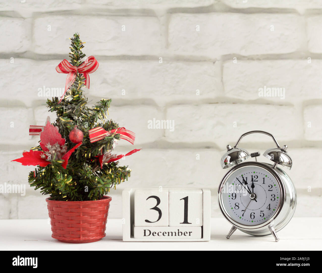 December, alarm clock and calendar on the table December 31 on a wooden ...