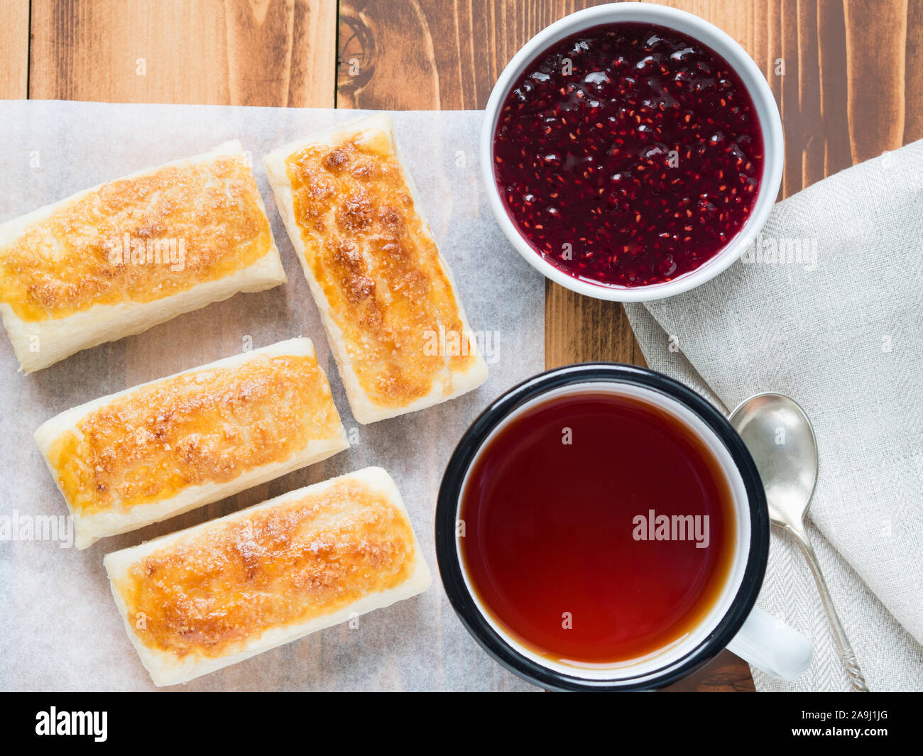 Breakfast of sweet rolls from puff pastry, raspberry jam, cup of tea on ...