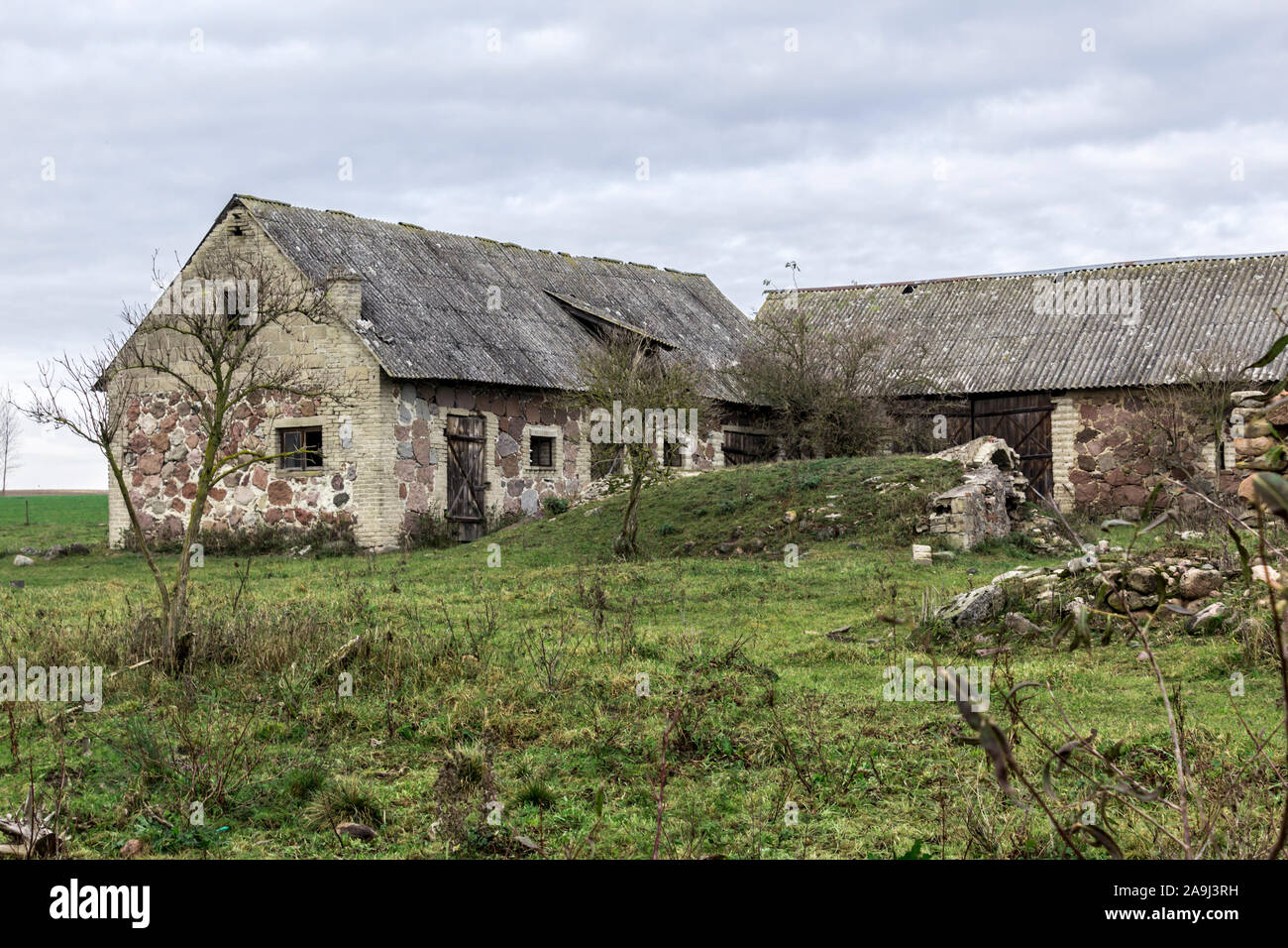 Late autumn. Old abandoned barns. A stone cellar in the foreground ...