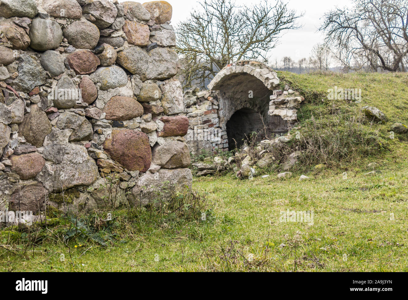 Late autumn. Yard of an old abandoned farm. Ruined cellar and a wall of ...
