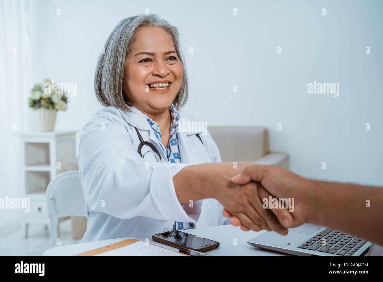Doctor and patient shaking hands Stock Photo - Alamy