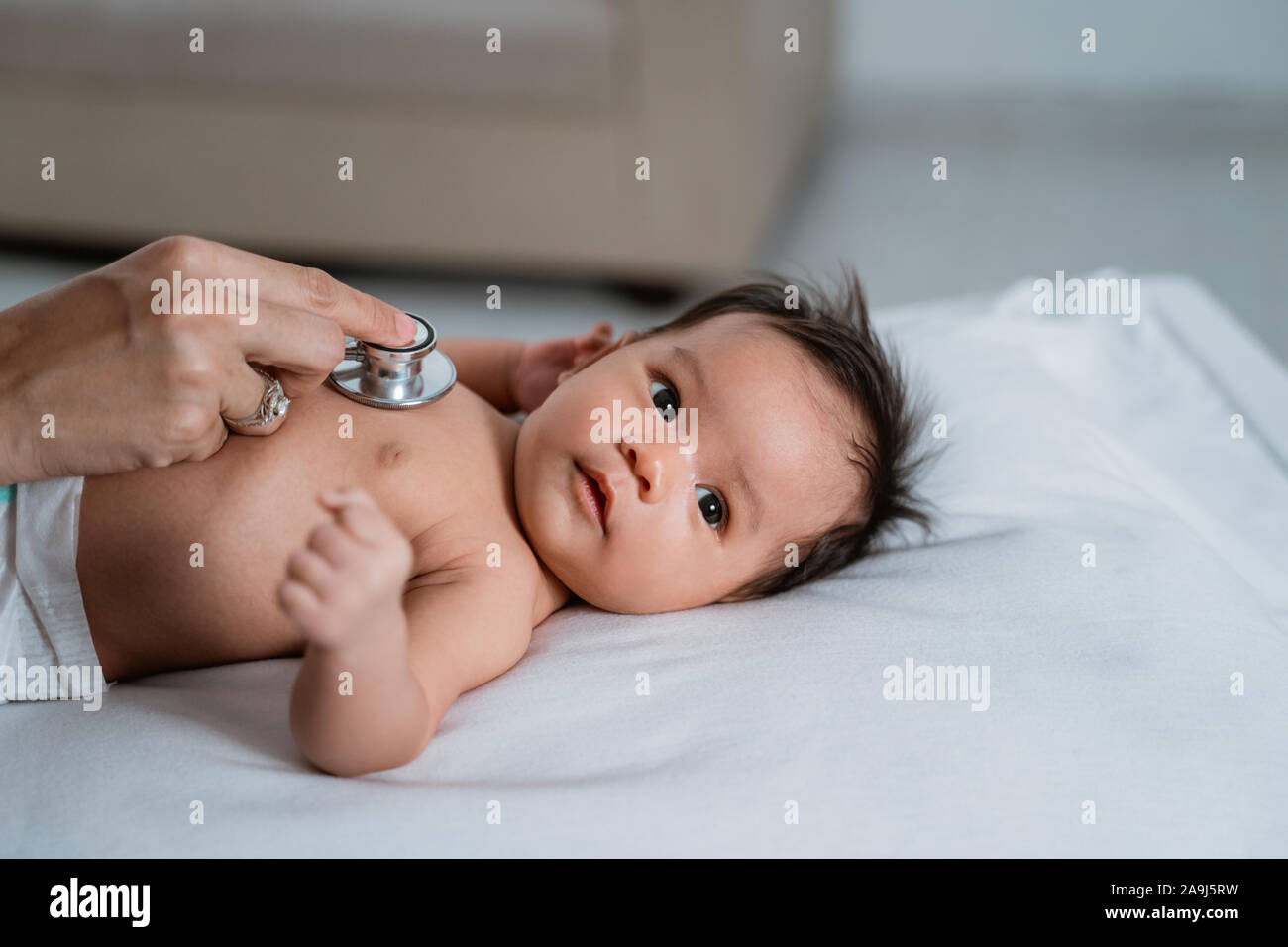 Pediatrician doctor examining baby girl Stock Photo - Alamy