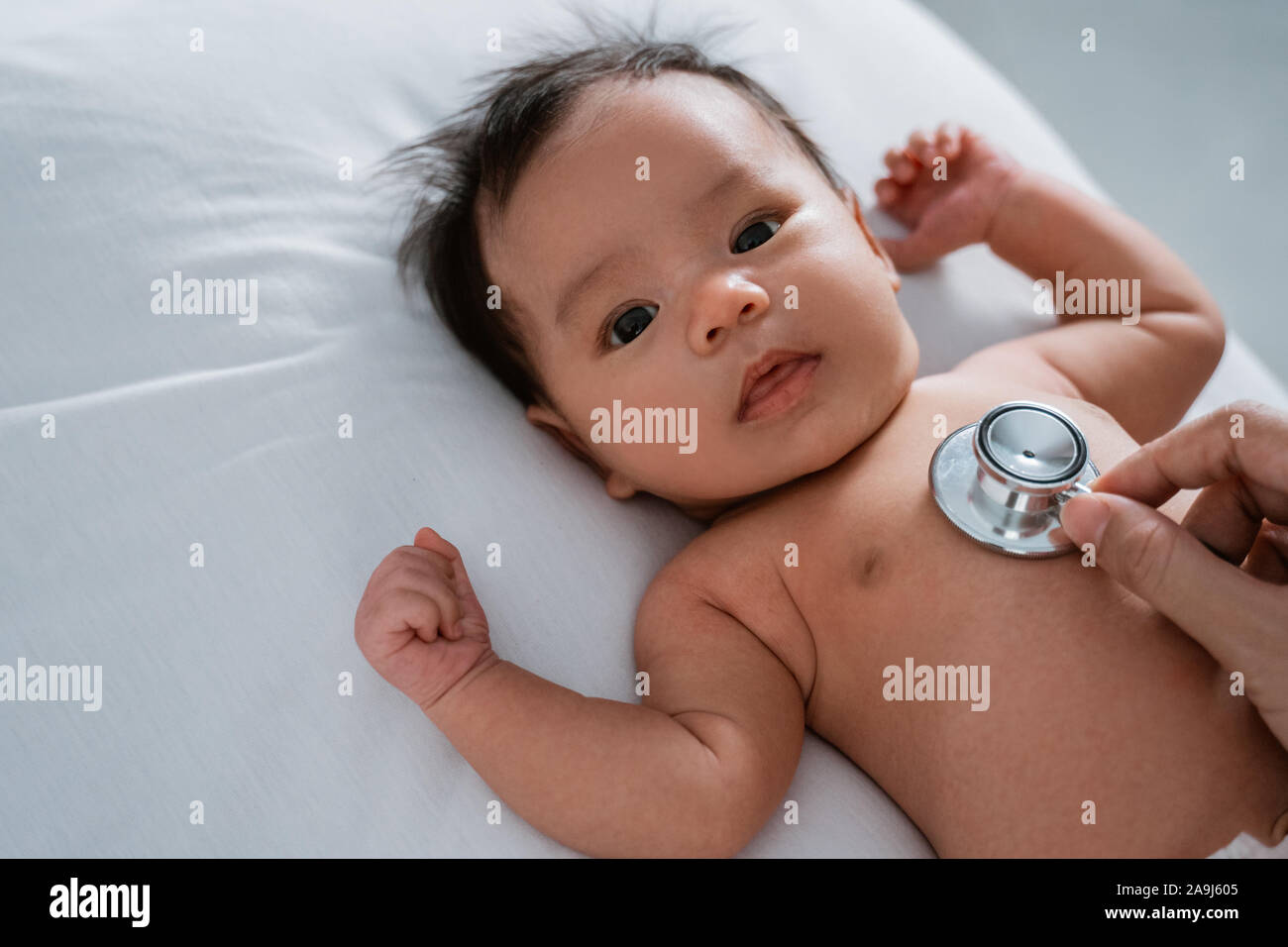 Pediatrician doctor examining baby girl Stock Photo - Alamy